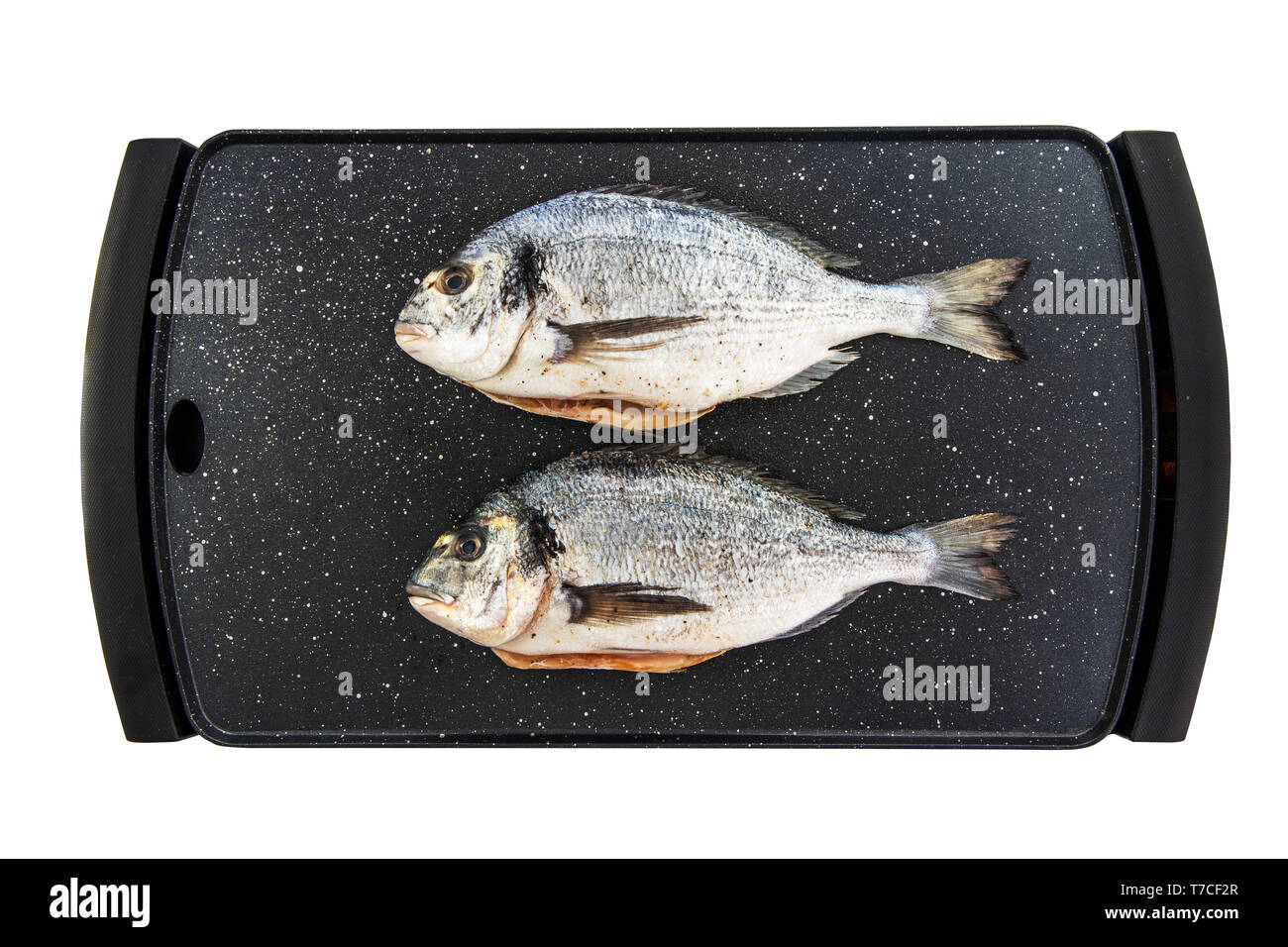 Sea bream fish on stone grill ready to be cooked isolated on white ...