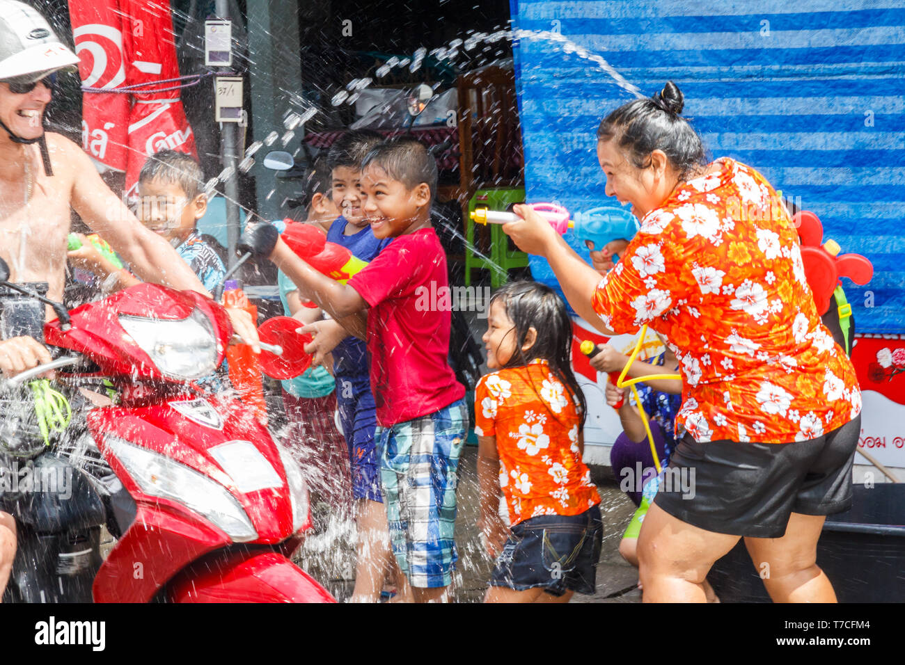 Phuket, Thailand - 13th April 2017: People on a motorbike drenched by ...