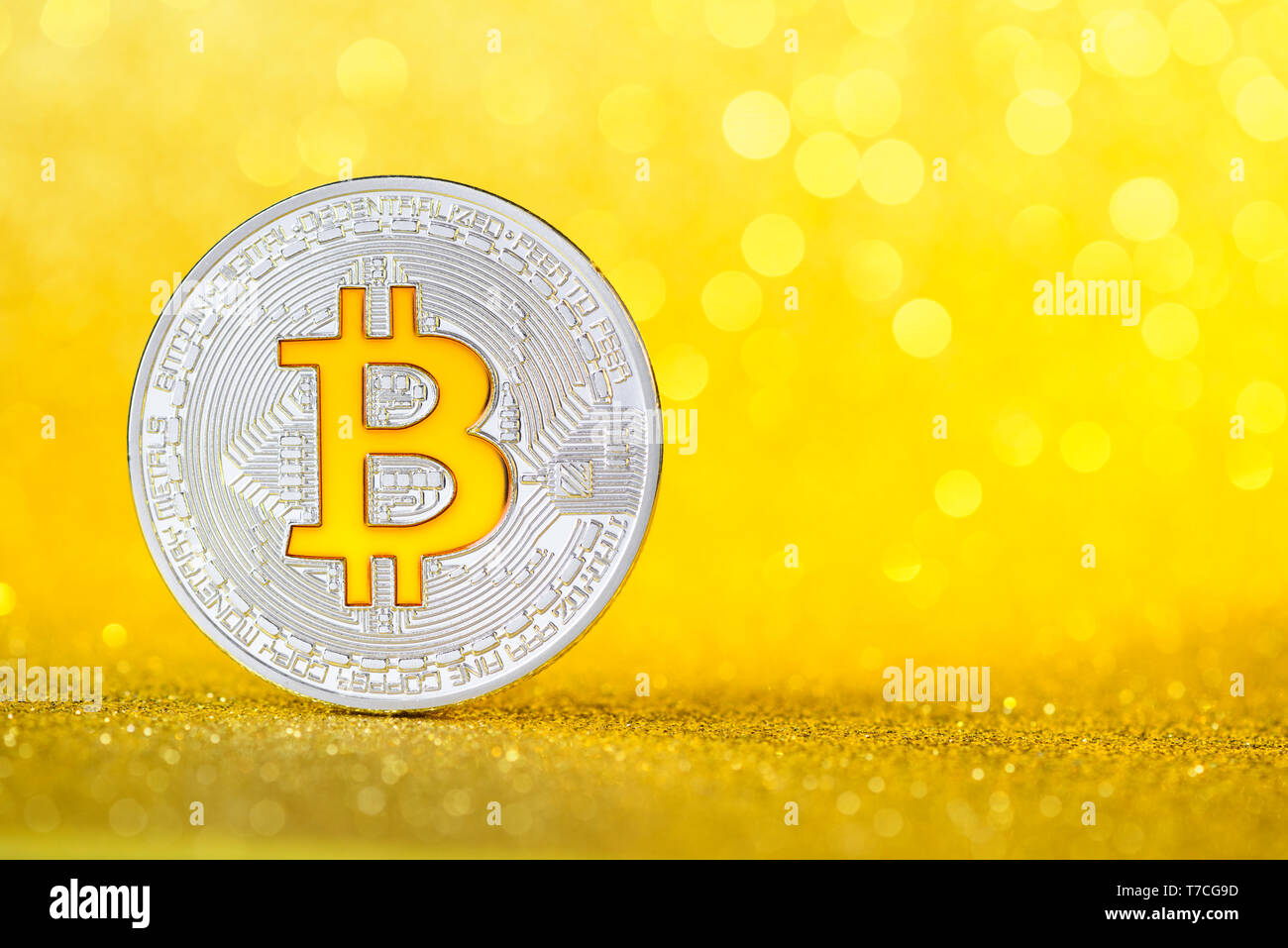 New shiny silver bitcoin coin with golder bitcoin B symbol on golden ...