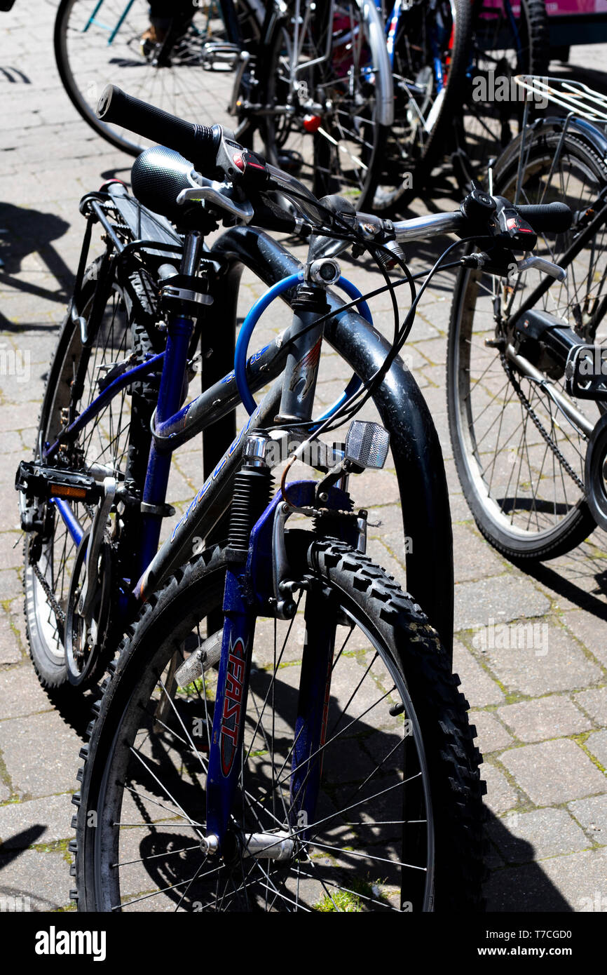 Bicycles chained to bike parking rack located in City centre shopping ...