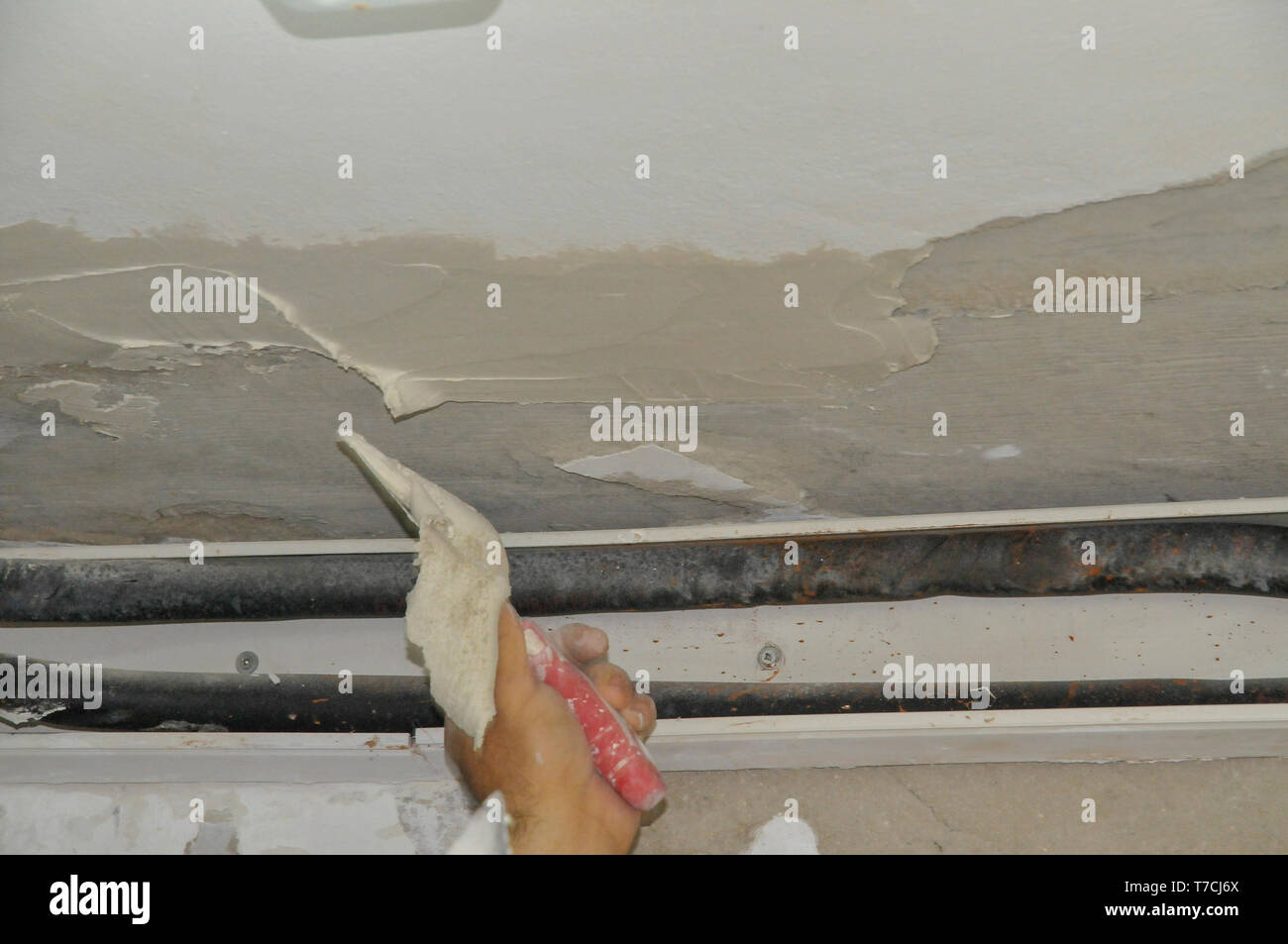 Home care. a room is being re plastered using a Putty knife. The ...