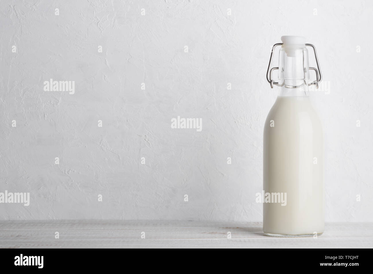 Bottle of milk with vintage swing top lock, closed, on white wooden ...