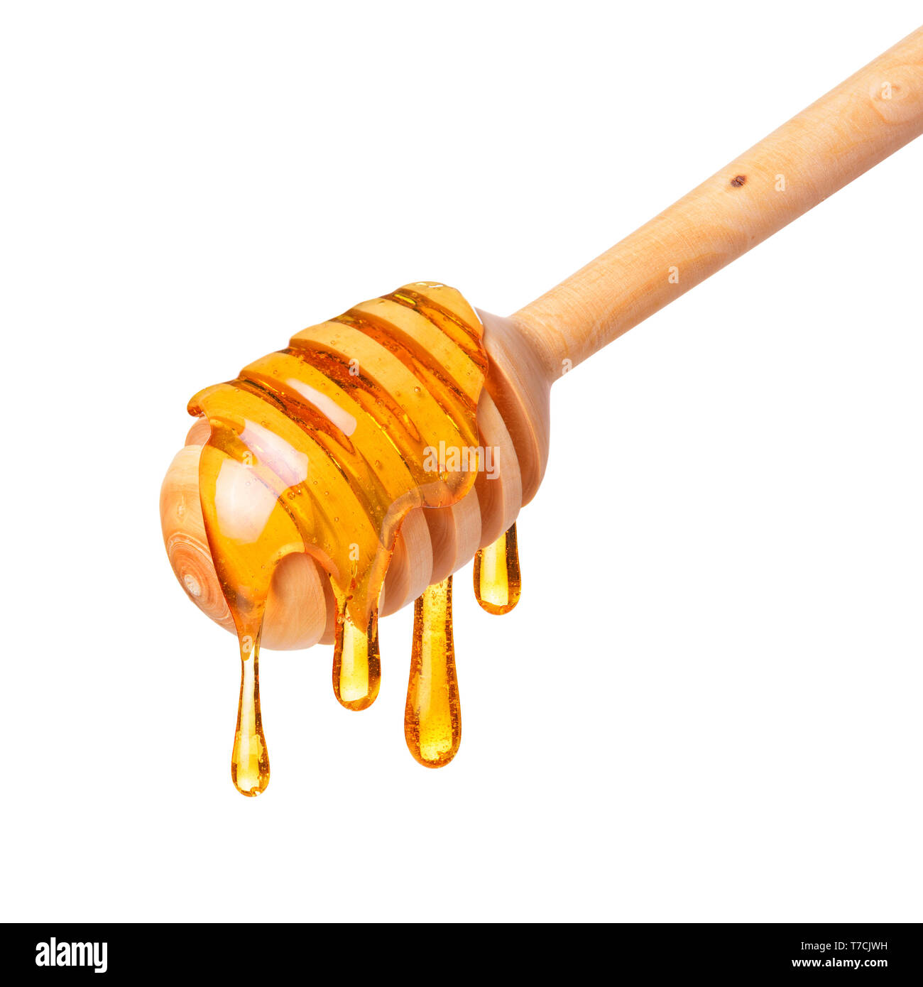 Honey dripping from wooden dipper spoon isolated on white background ...