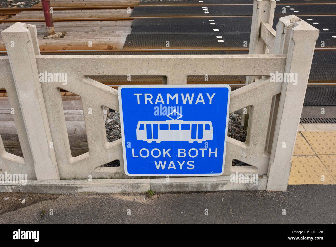 Tramway look both ways blue and white warning sign mounted on concrete ...