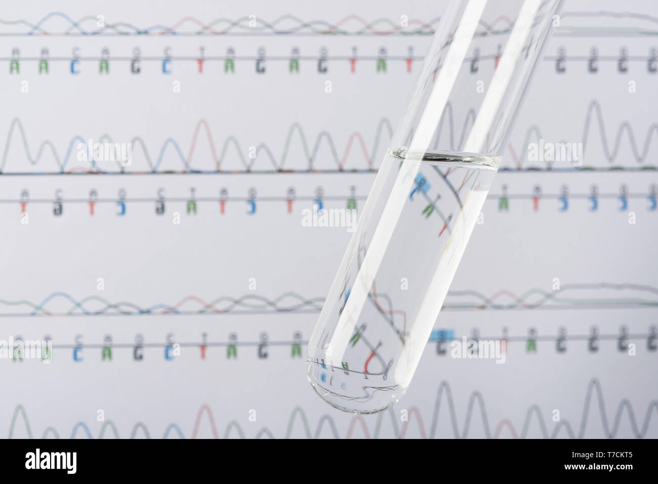 Test tube with transparent liquid and DNA chromatogram on background ...
