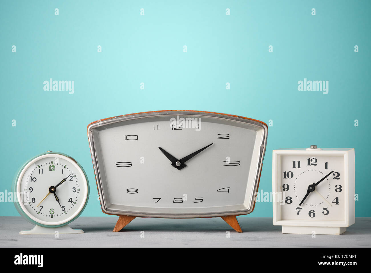 Retro clocks in a row on a table with blue background time concept ...