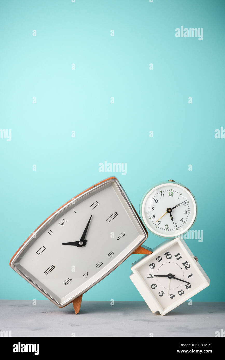 Retro alarm clocks tilted and stacked time concept on vintage blue ...