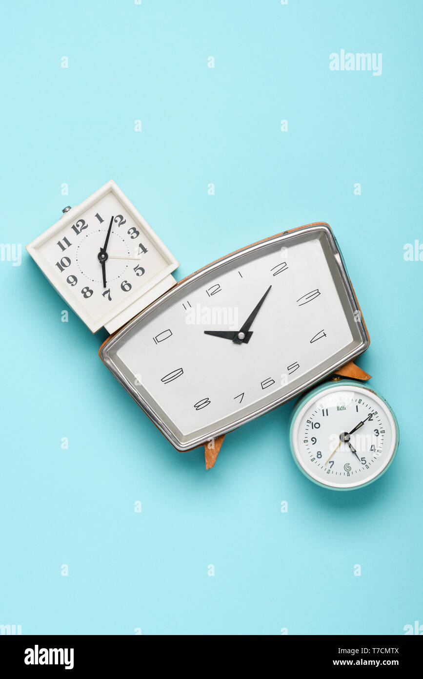 Different retro clocks on blue pastel background time concept flat lay ...