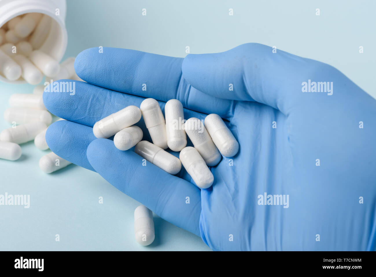 Pills medical drug capsules in doctor hand in glove Stock Photo - Alamy