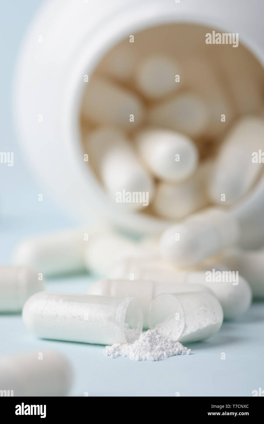 Medical capsule from bottle open with powder white substance macro ...