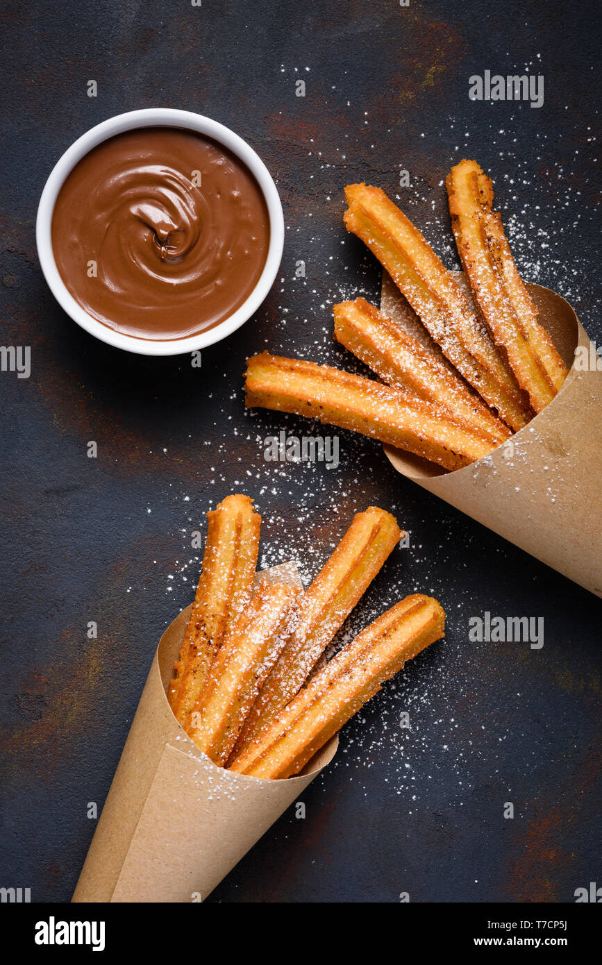 Fried traditional churro sticks with sugar powder cinnamon and bowl of ...