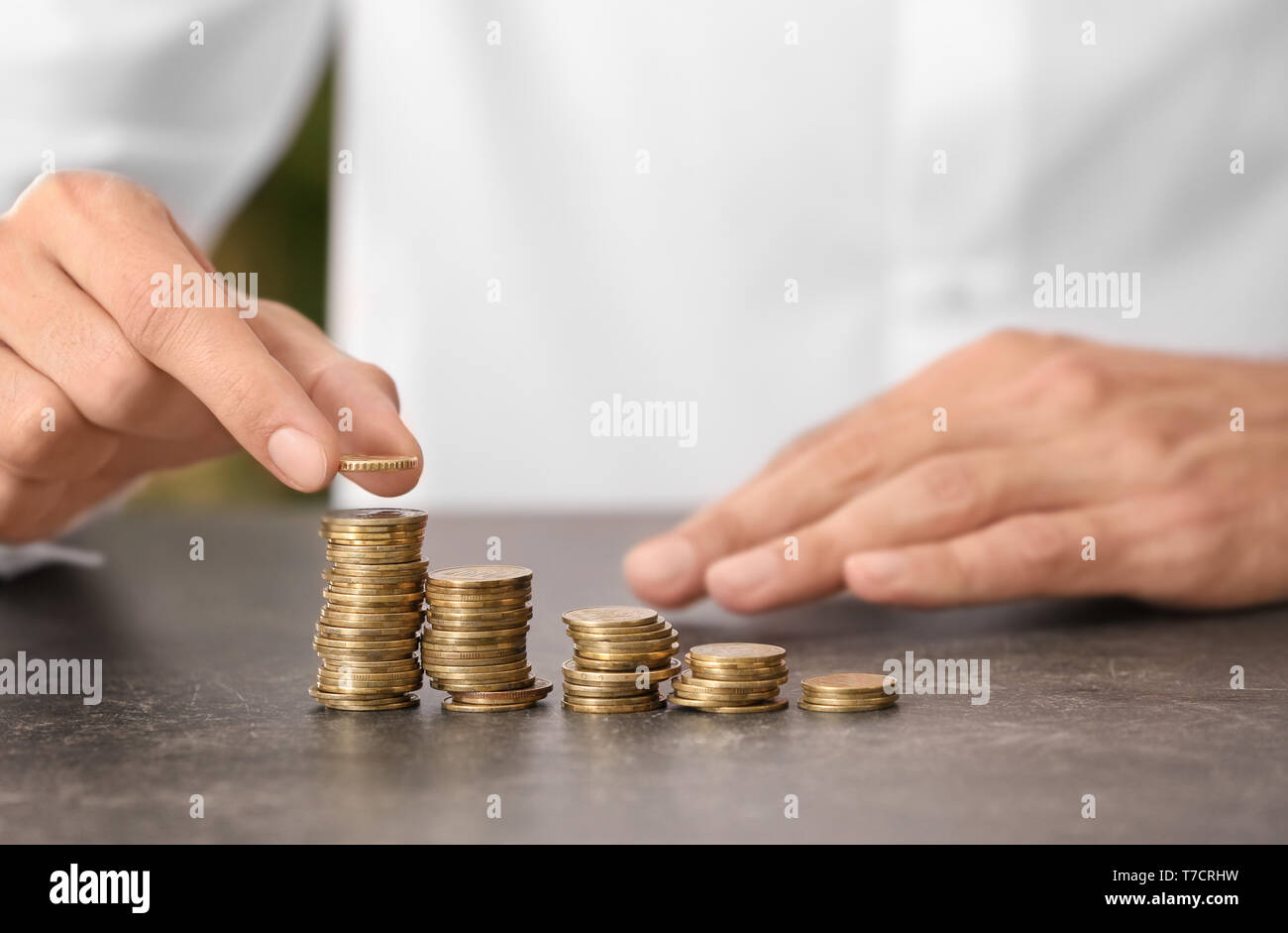 Man stacking coins table hi-res stock photography and images - Alamy