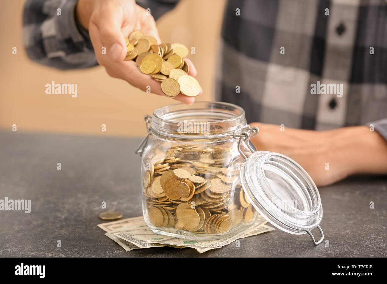 Pouring coin jar hi-res stock photography and images - Alamy