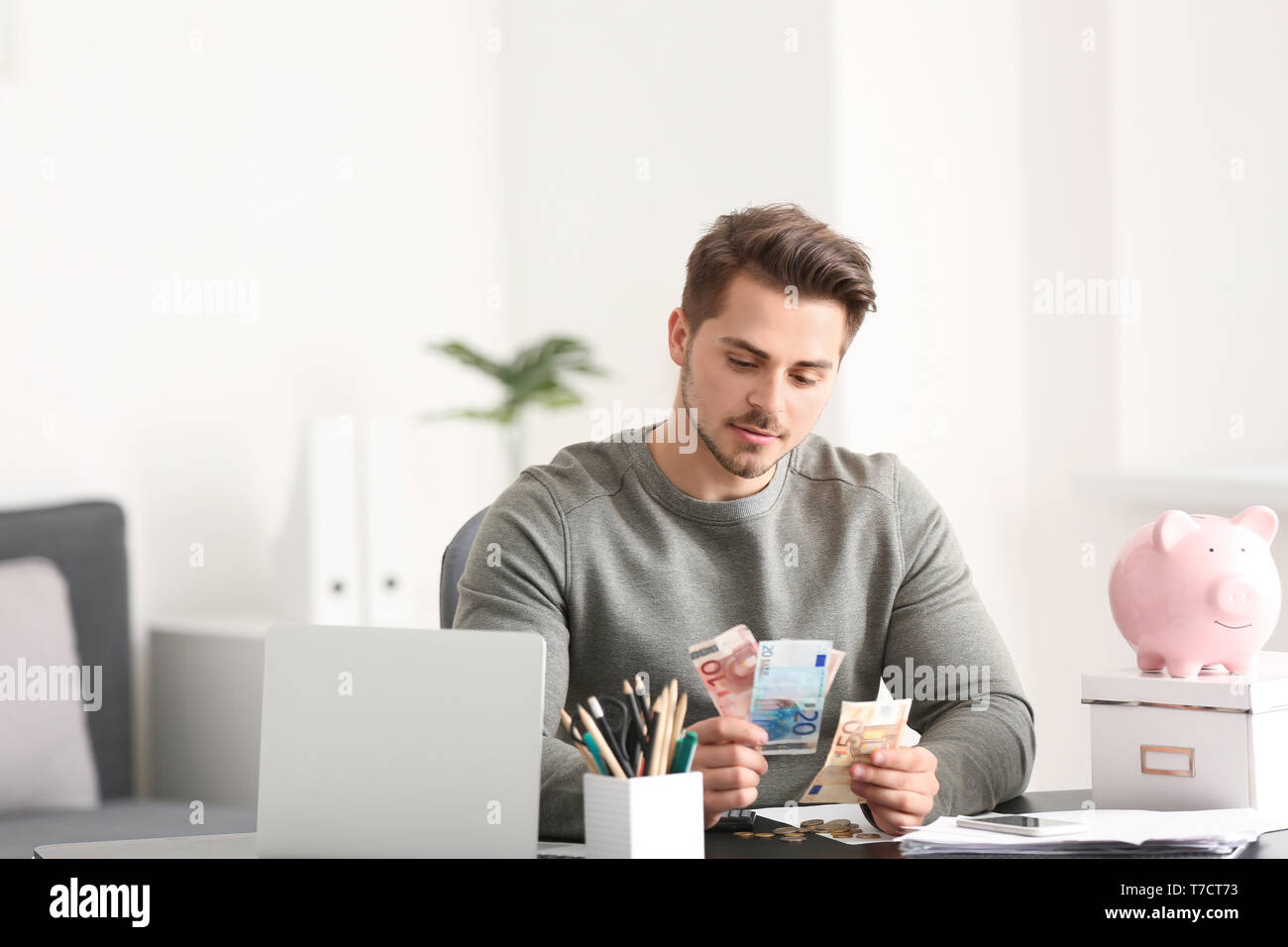 Young man counting euro coins hi-res stock photography and images - Alamy