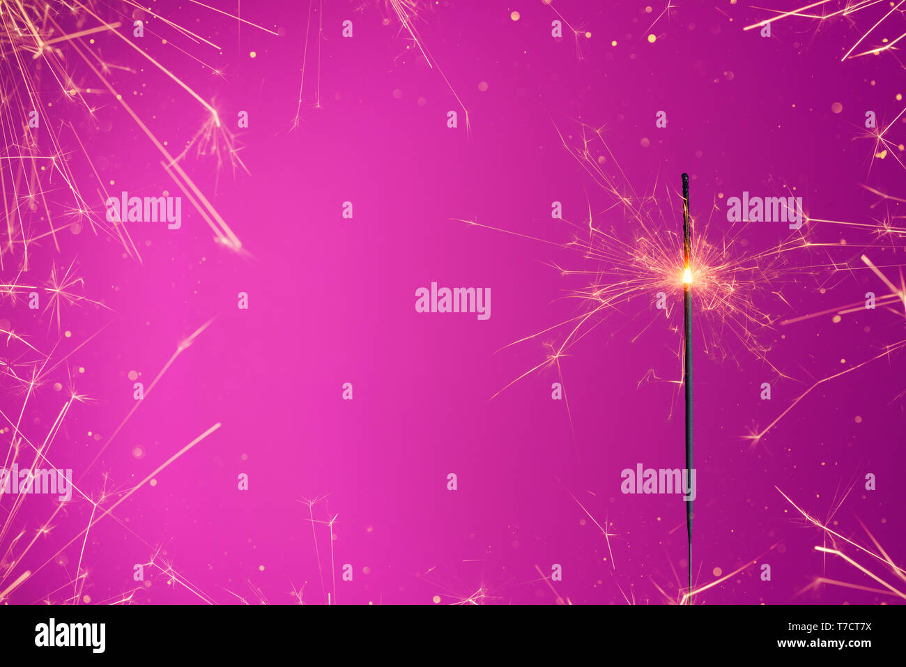 Burning sparkler bengal fire in frame of sparkles and gold glitter ...