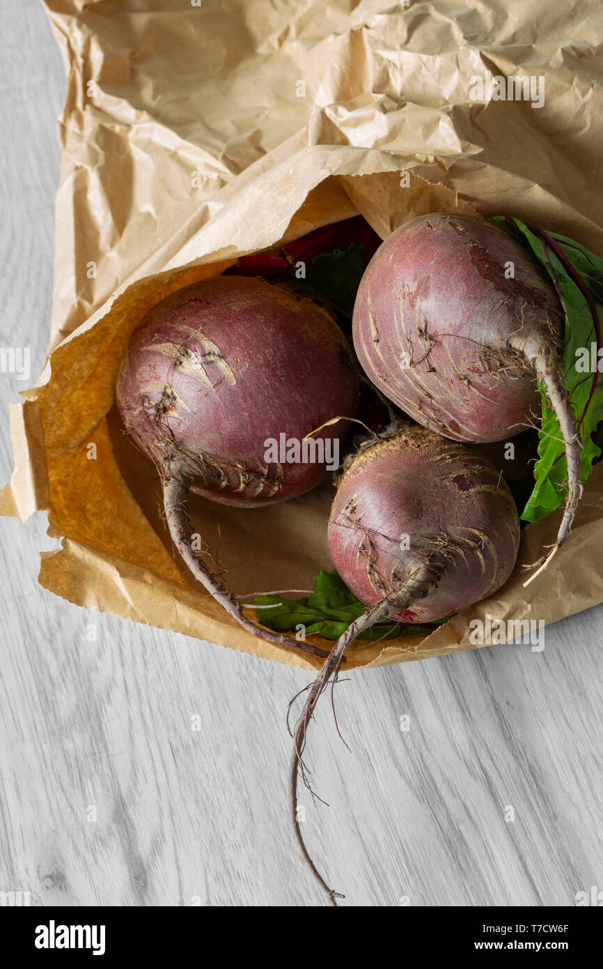 Organic beetroot in a brown paper bag on grey wood. Recycle packaging ...