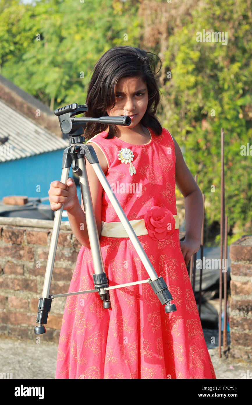 little girl holding a tripod in her hand on the roof Stock Photo - Alamy