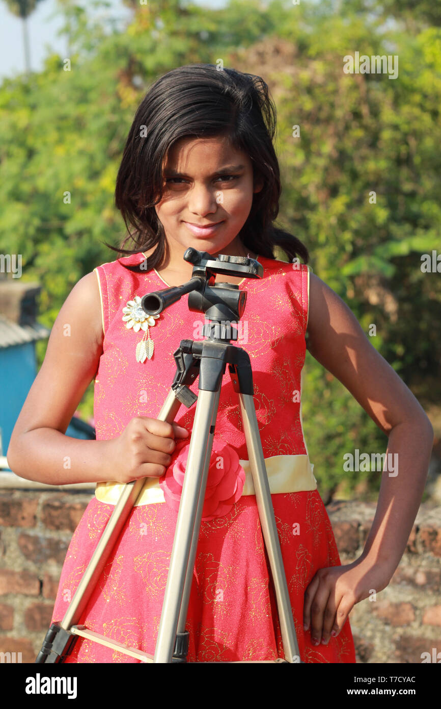 little girl model holding a tripod in her hand Stock Photo - Alamy