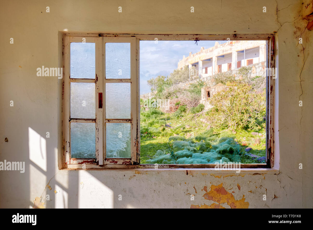 Interior of a desolated house and a window frame with broken glass ...