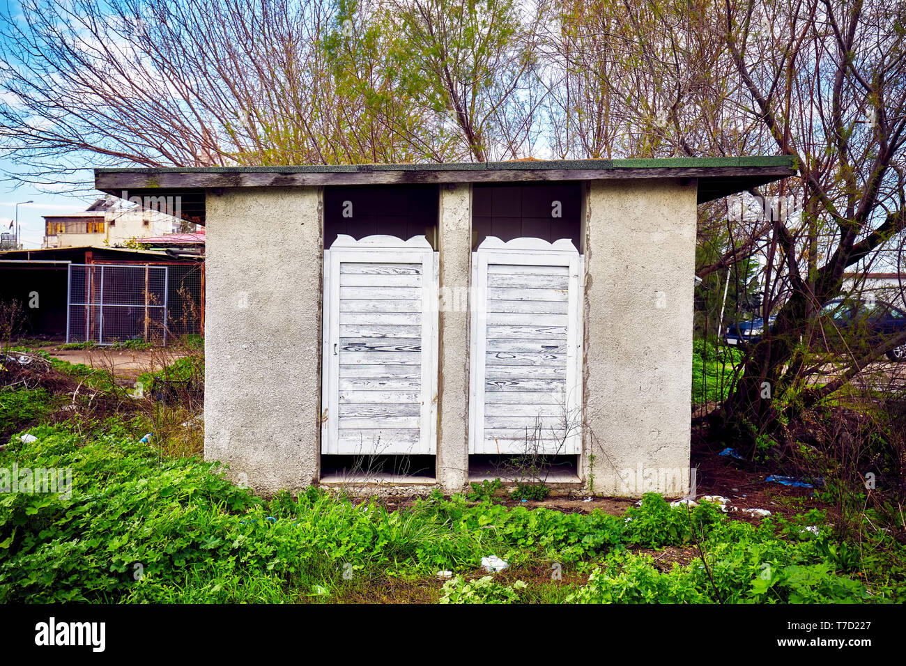 Exterior of an outdoor changing room with white wooden door in a meadow ...