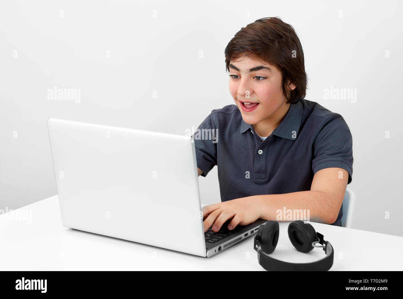 Smiling Caucasian teenage kid looking surprised and having fun while ...