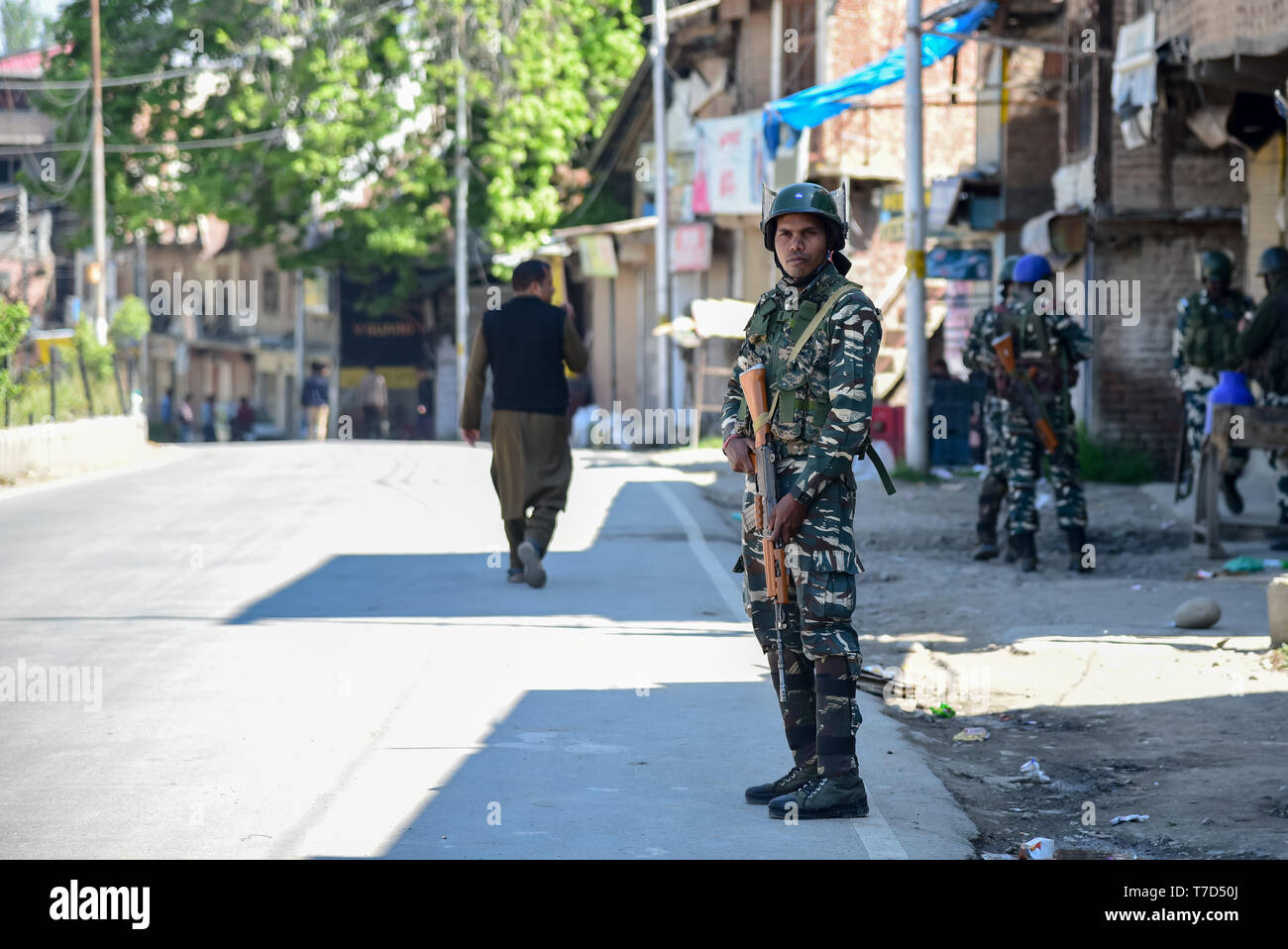An Indian paramilitary man seen standing on guard near a polling ...