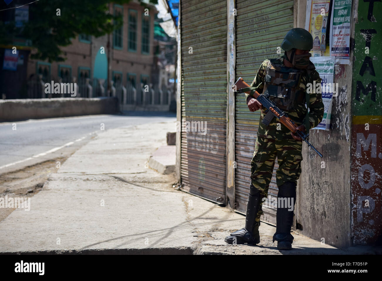 An Indian paramilitary man seen standing on guard near a polling ...