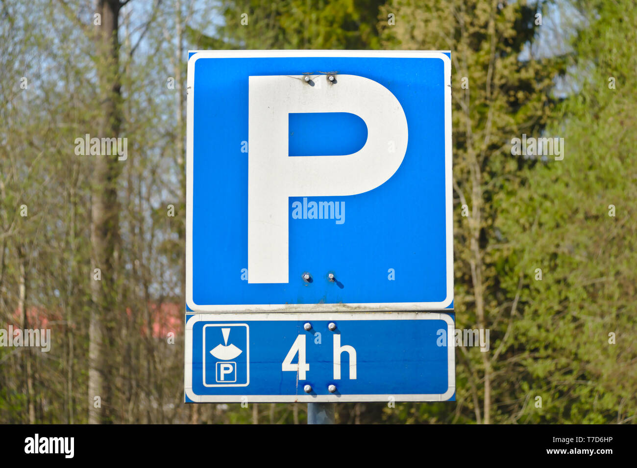 Square sign in parking lot that allows parking up to 4 hours with a ...