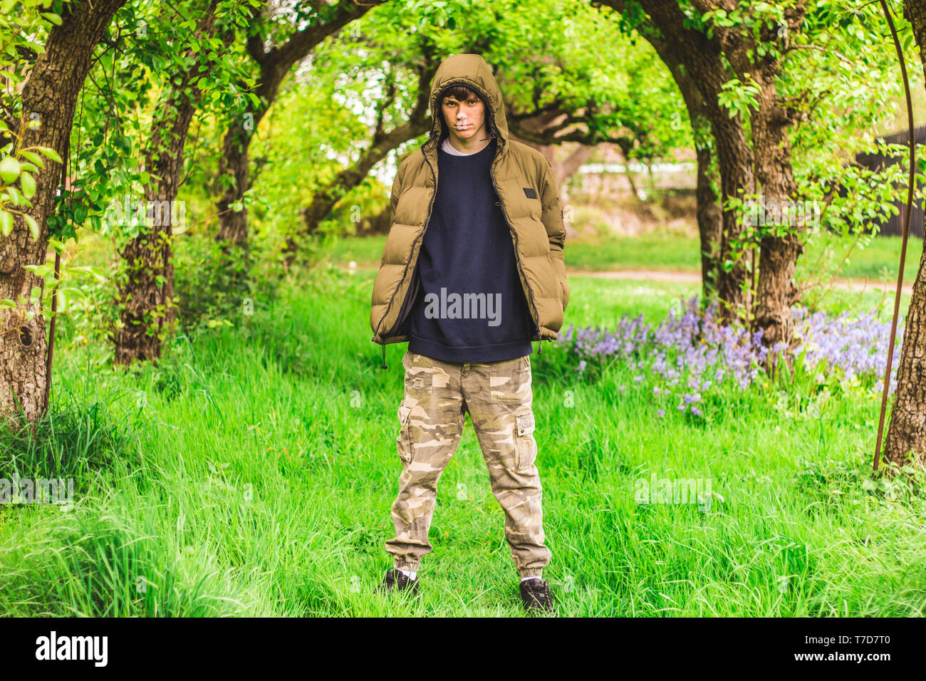 Model standing under archway created by trees wearing camo pants Stock ...