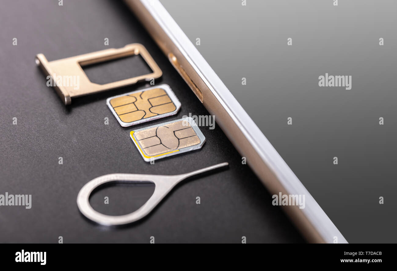 mobile phone and sim card on a black background Stock Photo - Alamy
