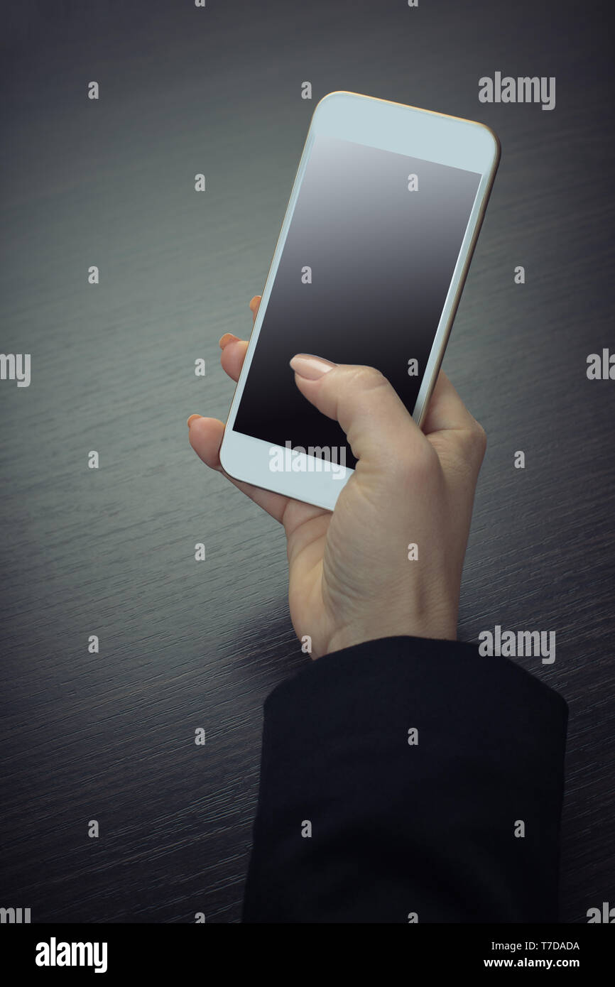 mobile phone in female hand on a wooden background Stock Photo - Alamy