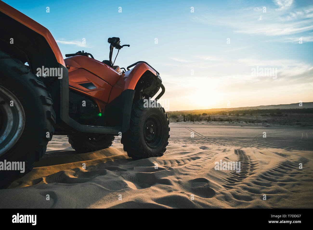 ATV Quad Bike in front of sunrise in the desert. ATV stands in the sand ...