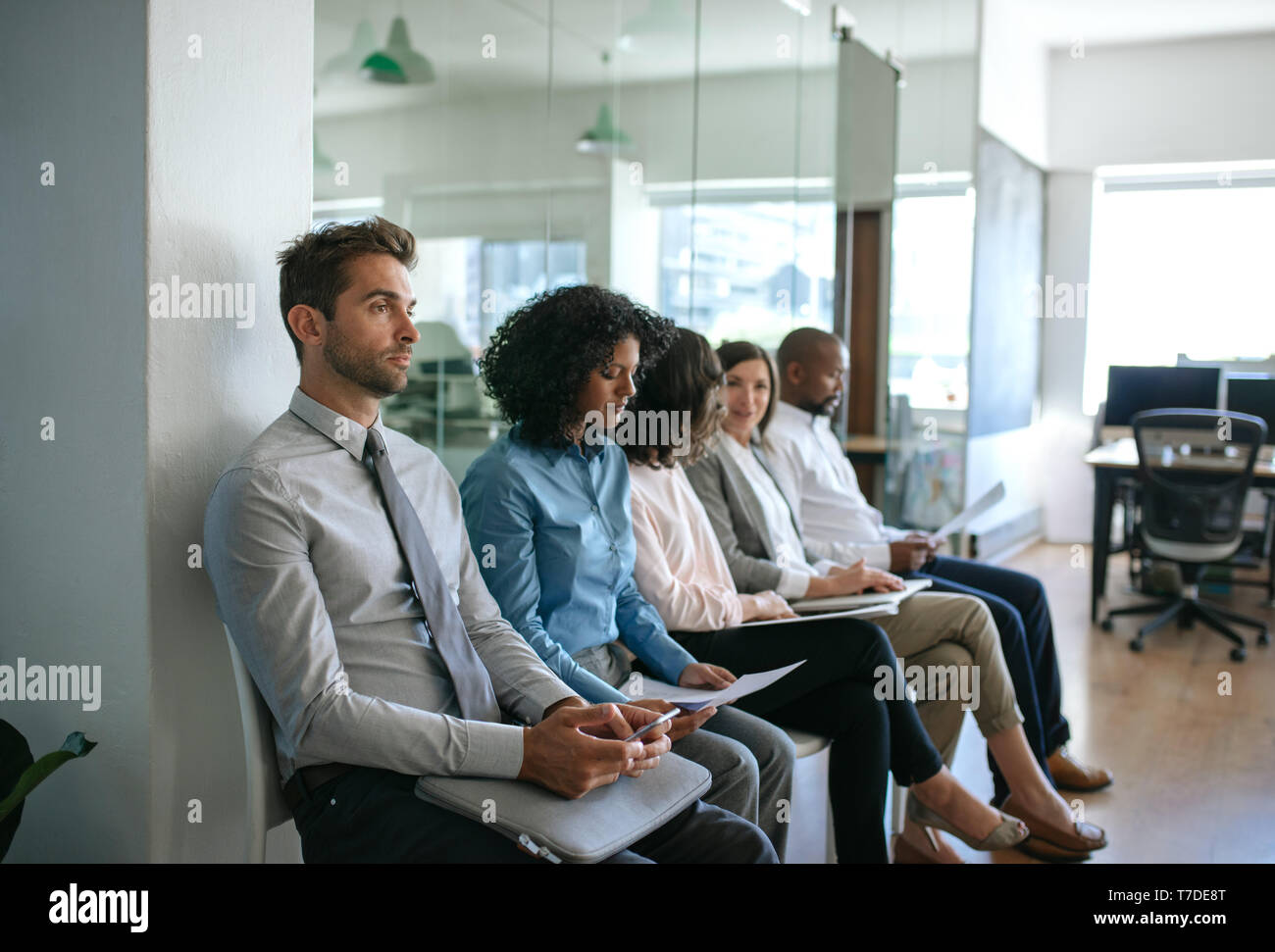 Group of diverse people waiting for interviews in an office Stock Photo ...