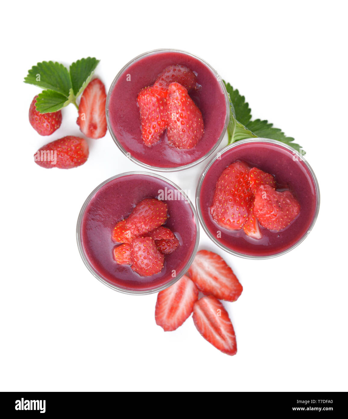 top view on red fruit coulis and strawberries in glass isolated on ...