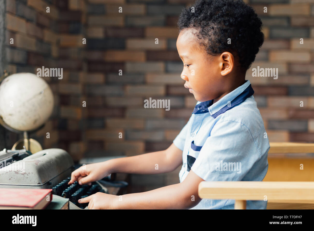 African American boy typing on typewriter in living room - curiousity ...