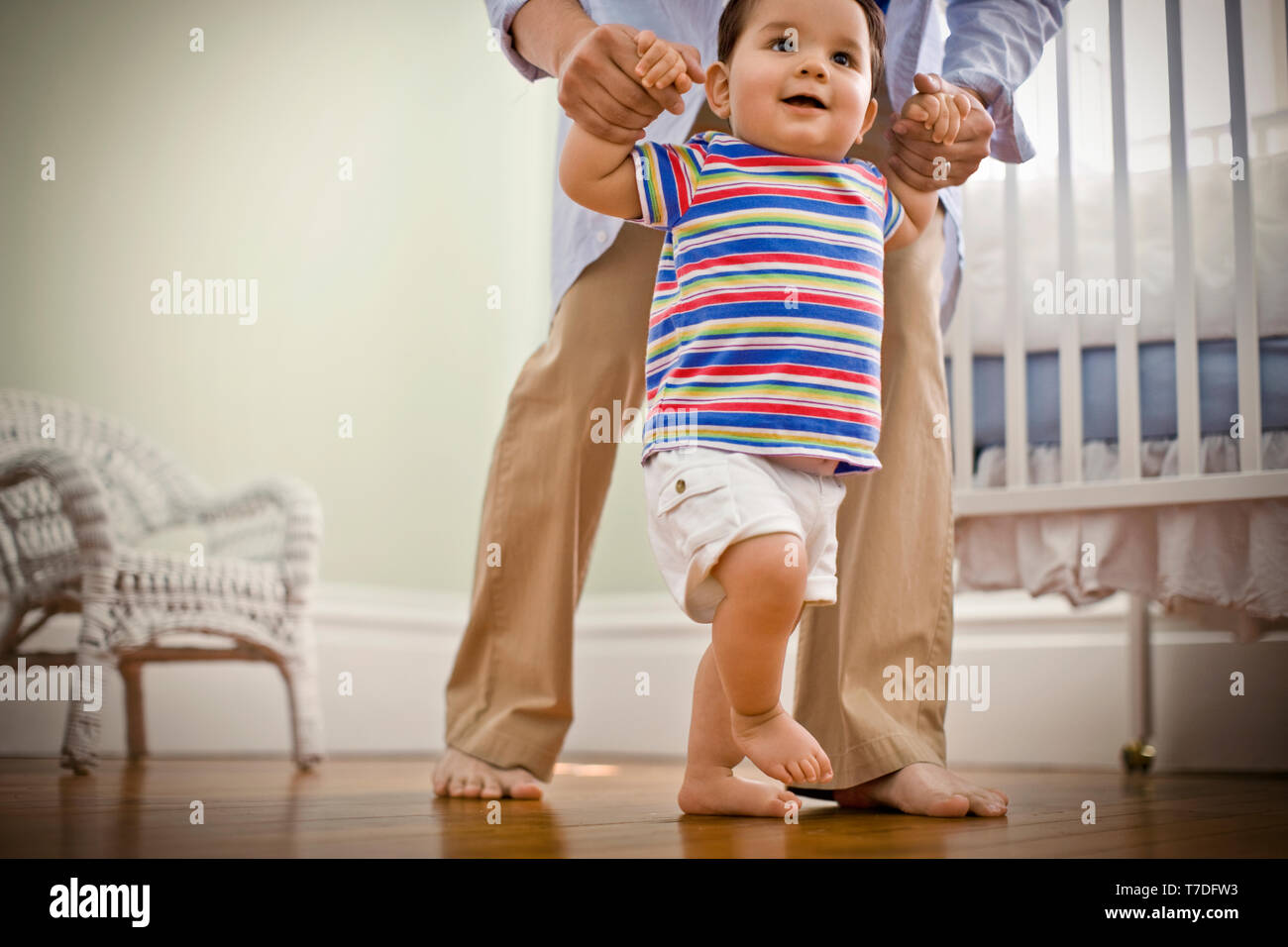 Toddler being helped to walk by his father Stock Photo - Alamy