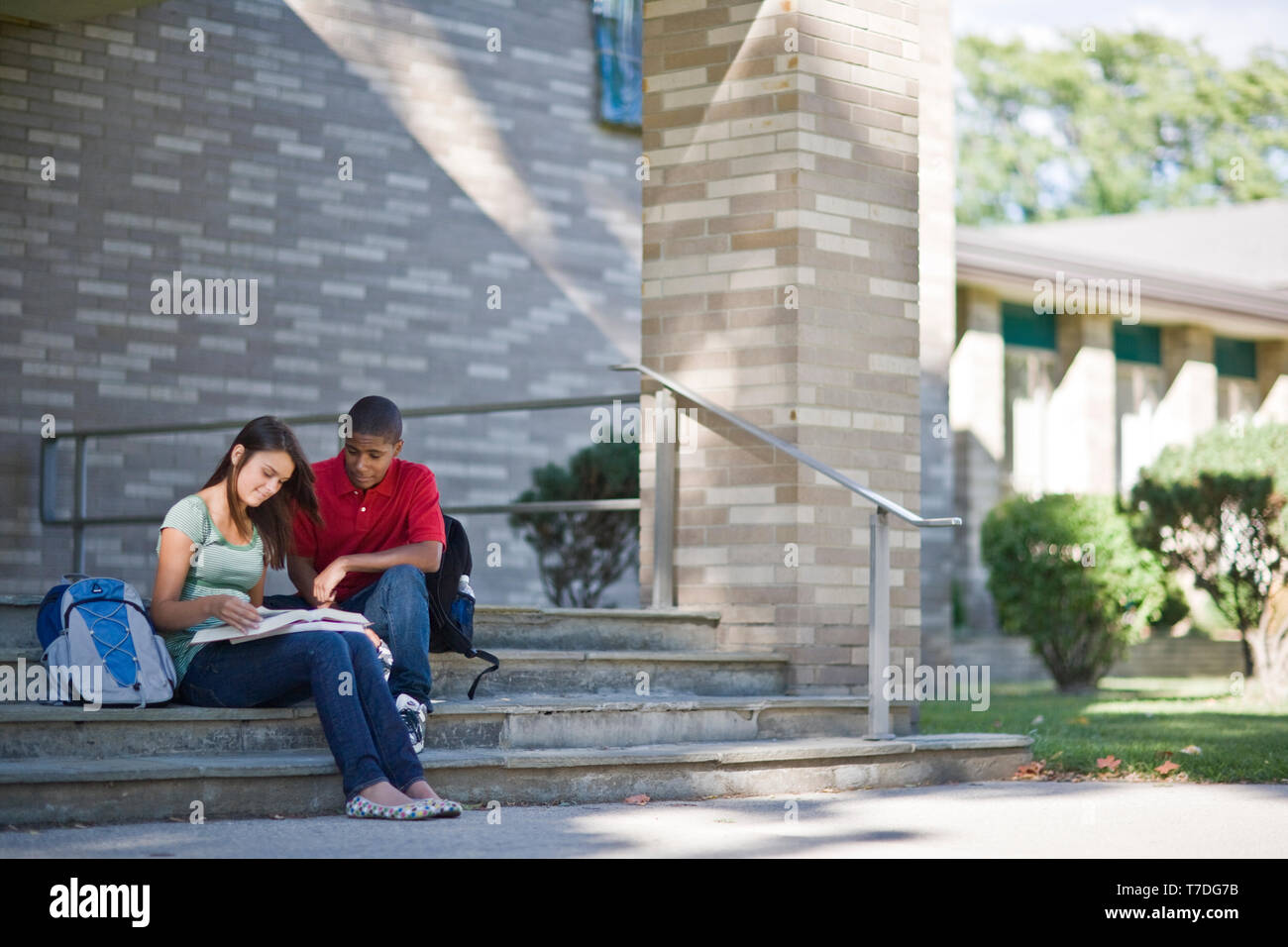 Teenage boy and girl studying on school steps Stock Photo - Alamy