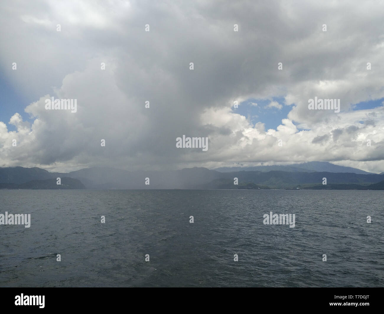Rain clouds over water, with localised rain shower Stock Photo - Alamy