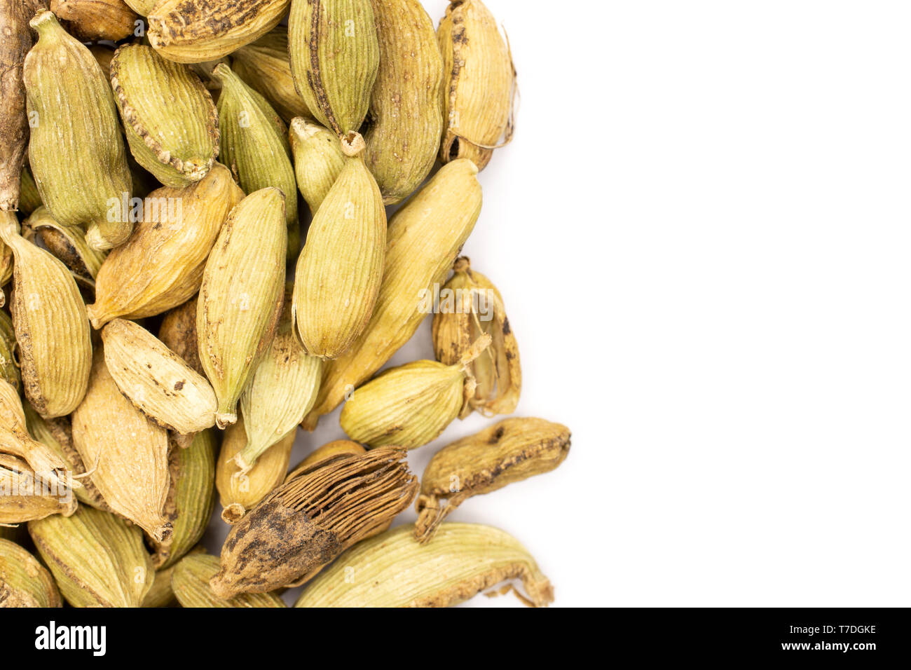 Lot of whole true cardamom pod on the left side with copyspace flatlay ...