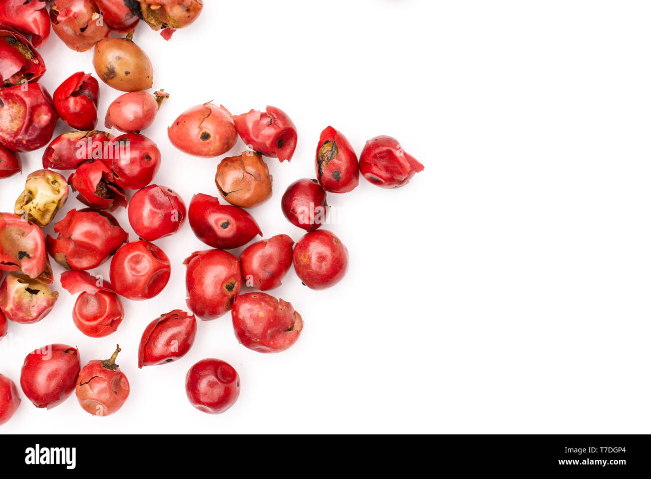Lot of whole dry peruvian pink pepper on the left side flatlay isolated ...