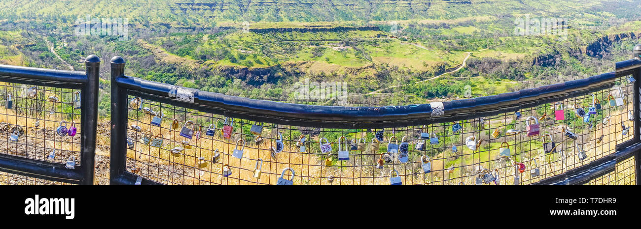 Many lover's padlocks and other locks are locked to the fence ...