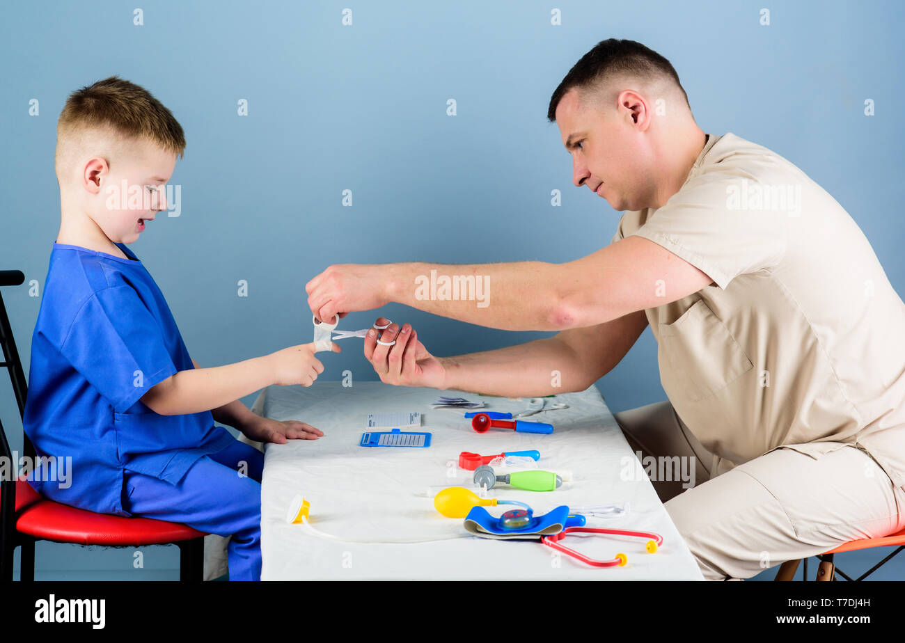 Man doctor sit table medical tools examining little boy patient ...