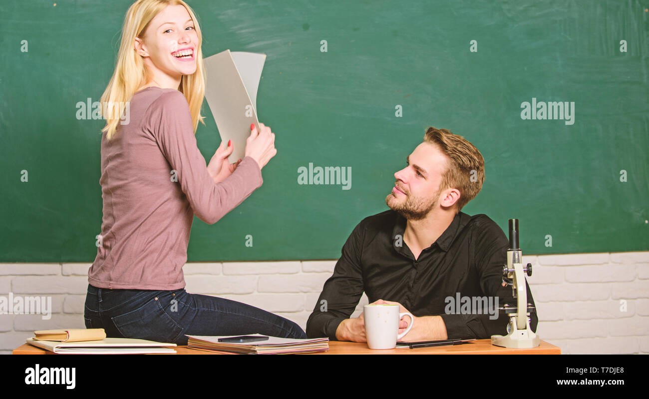 Satisfied with her marks. Couple studying in classroom. Pretty teacher ...