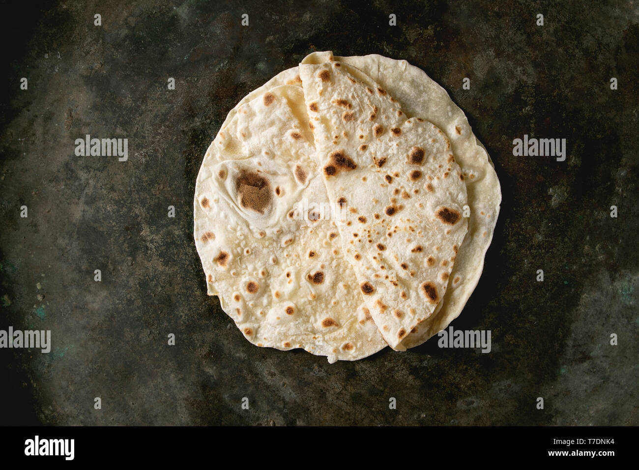 Homemade pita or chapati flatbread flapjack over dark metal background ...