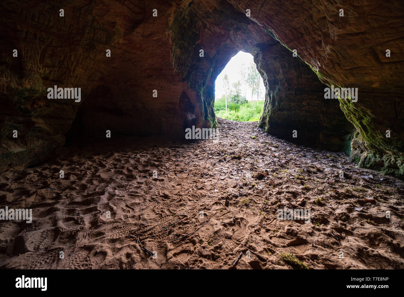 sandstone cave entrance in dark. sand covered ground. latvia Stock ...