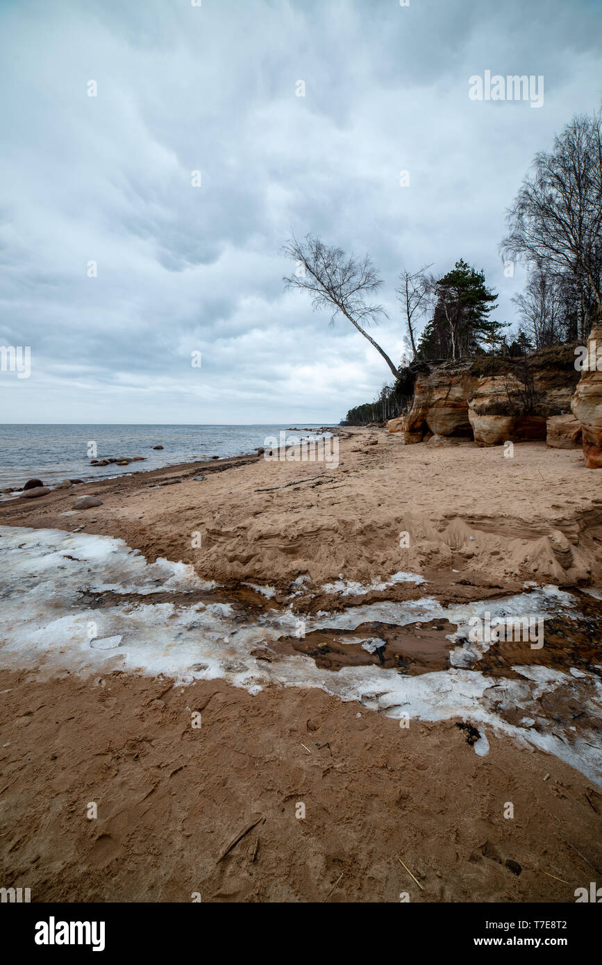 sandstone cave entrance in dark. sand covered ground. latvia Stock ...