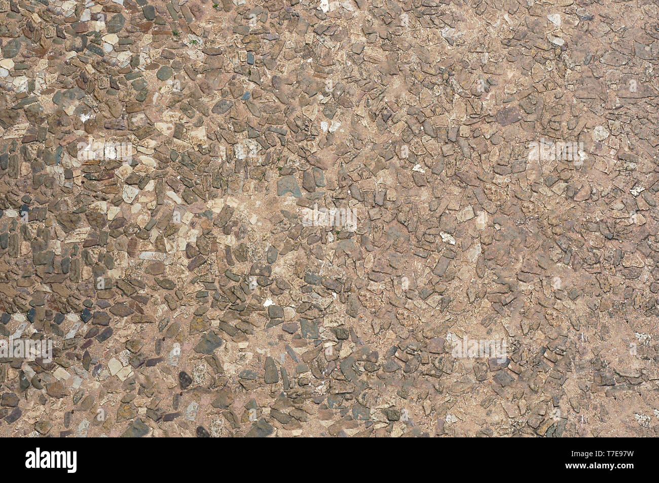 The wall of brown color is made of small stone .Texture or background ...