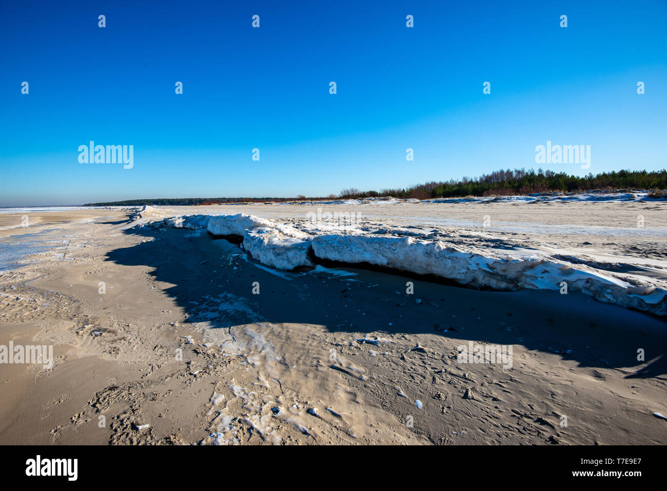 frozen sand textures in winter by the sea beach with blue sky in sunny ...
