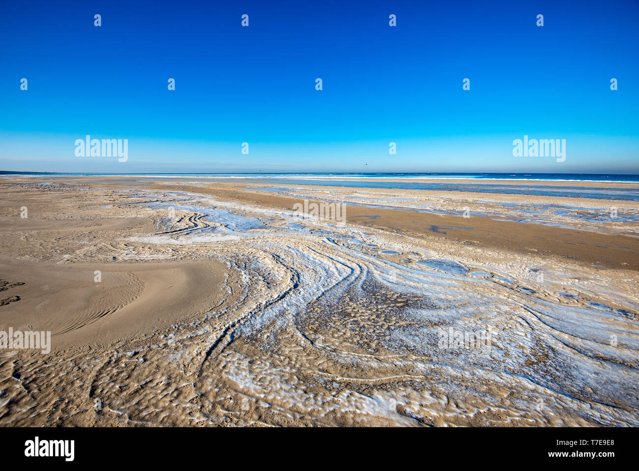 frozen sand textures in winter by the sea beach with blue sky in sunny ...