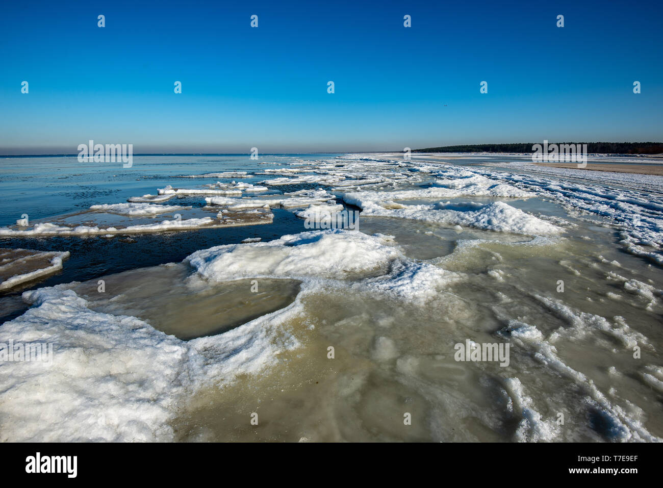 frozen sand textures in winter by the sea beach with blue sky in sunny ...